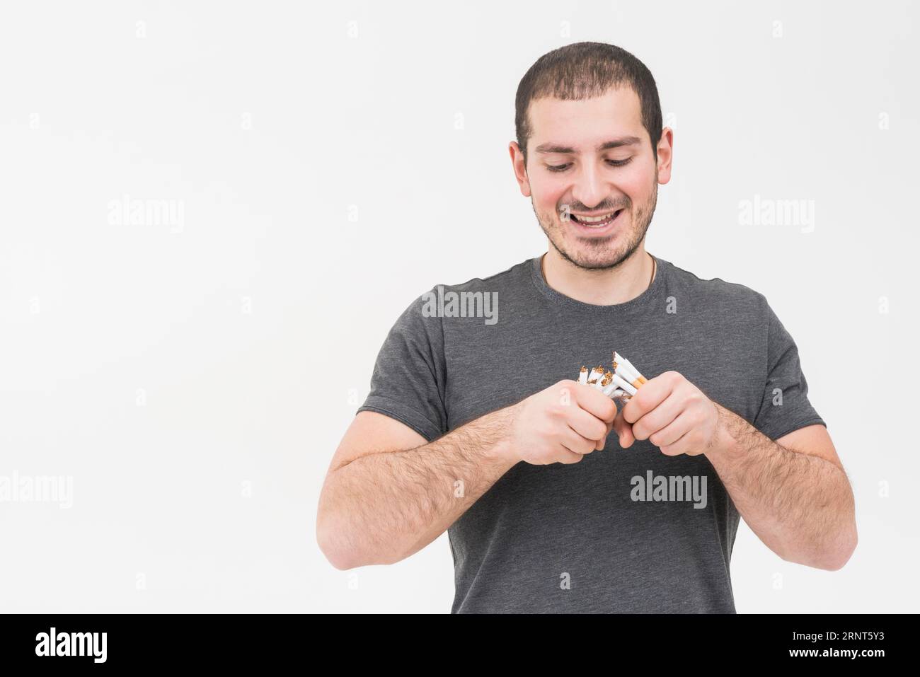 Portrait young man breaking heap cigarettes isolated white background ...