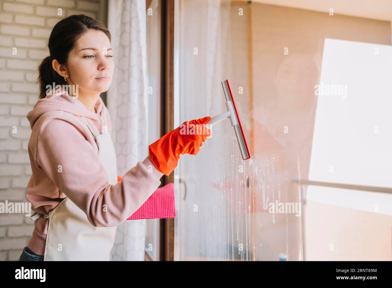 Side view woman cleaning window Stock Photo - Alamy