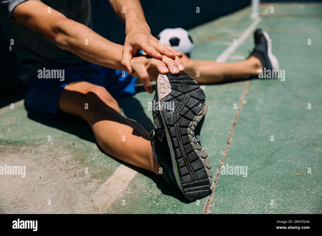 Teenager stretching foot football pitch Stock Photo - Alamy