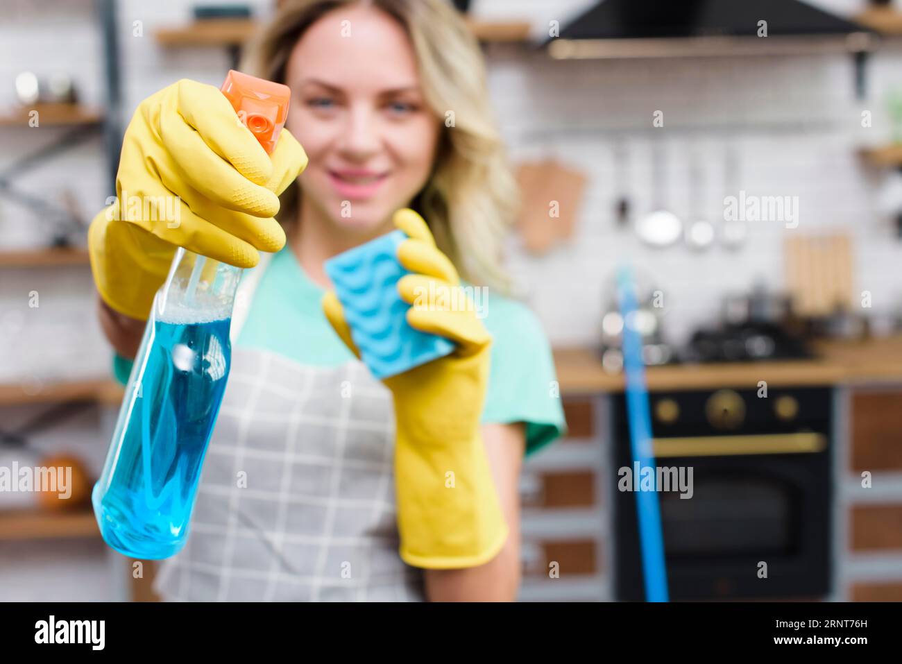 Young female cleaner showing detergent spray bottle Stock Photo - Alamy