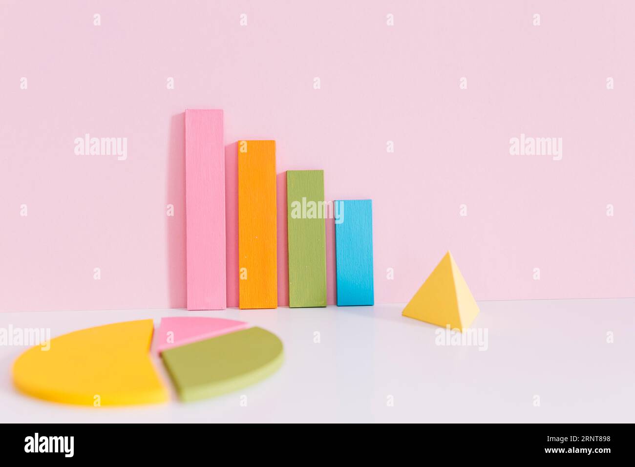 Colorful bar graph pie chart yellow pyramid desk pink background Stock ...