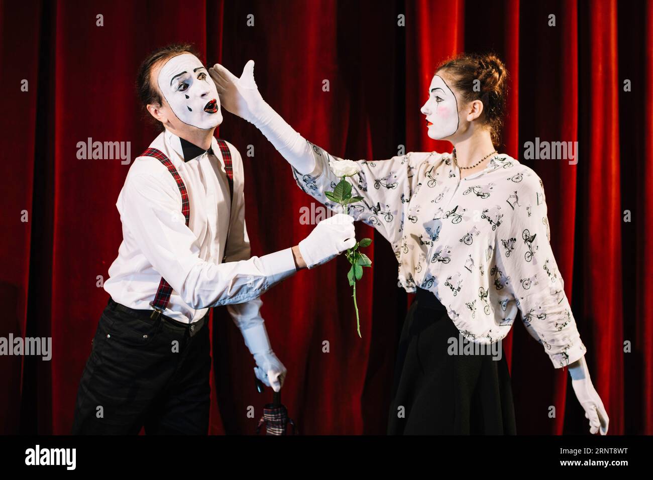 Female mime artist giving slap male mime holding white rose Stock Photo ...