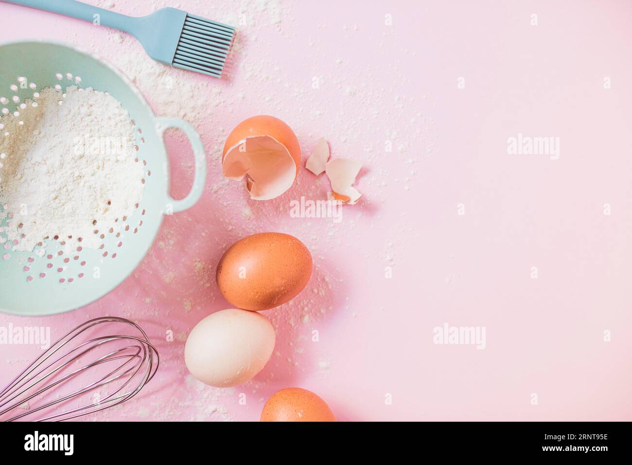 Flour colander eggs whisk against pink background Stock Photo - Alamy