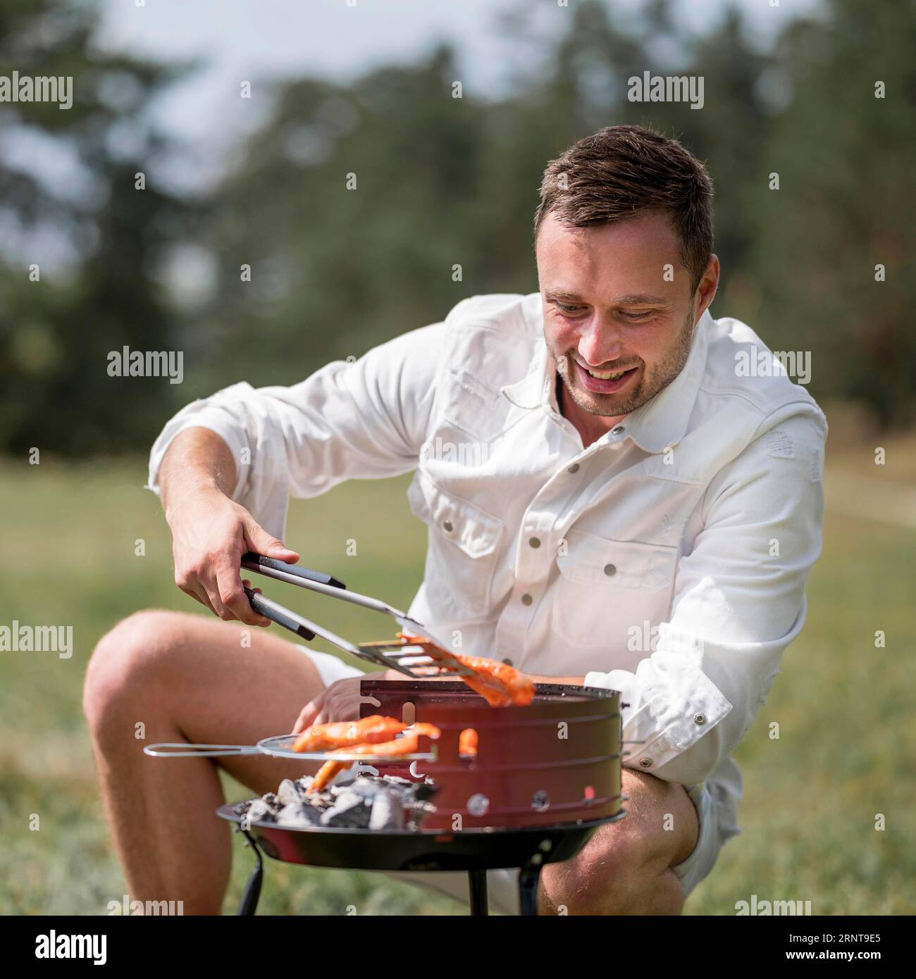 Front view smiley man attending barbecue outdoors Stock Photo - Alamy
