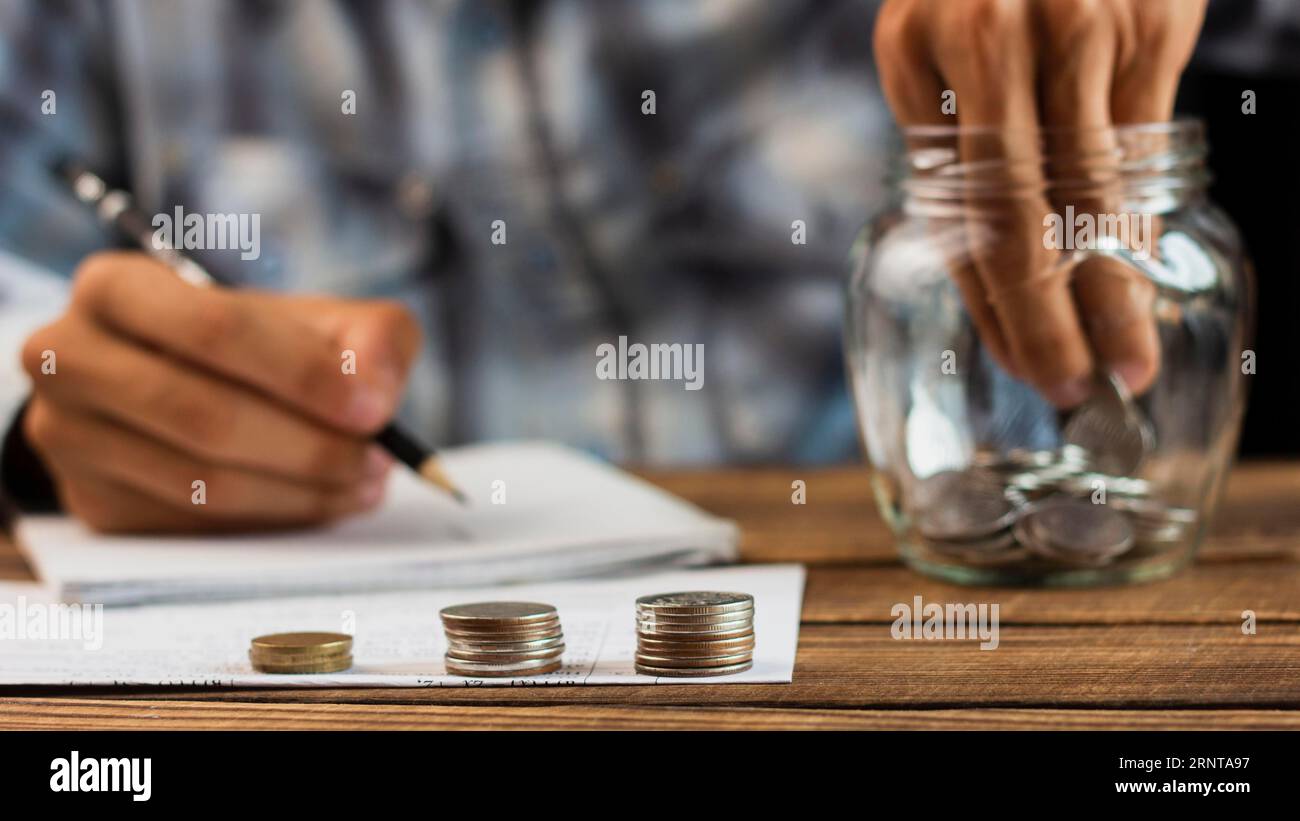 Man taking out coins from saving jar Stock Photo - Alamy