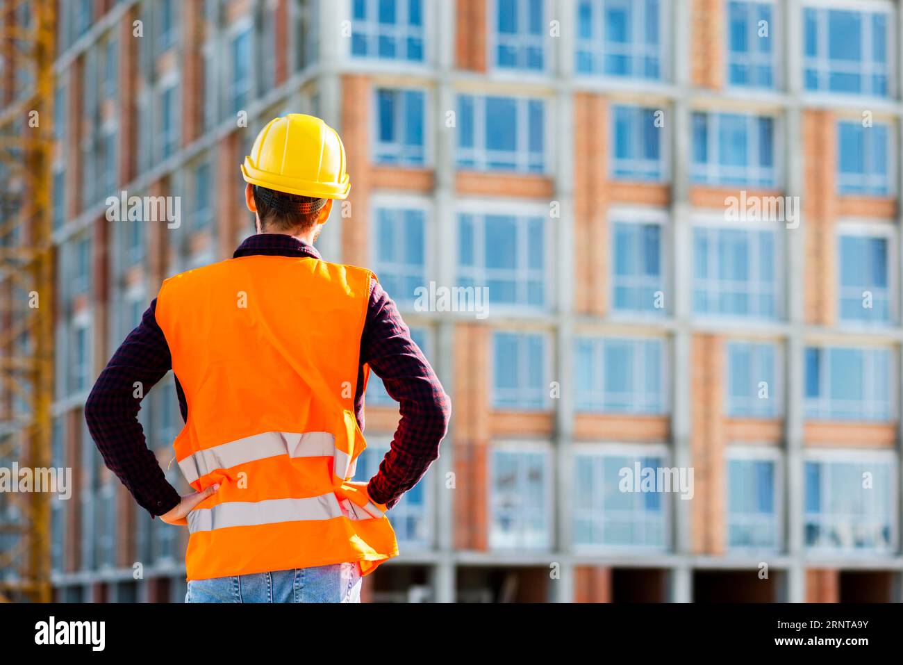 Medium shot back view engineer supervising construction Stock Photo - Alamy