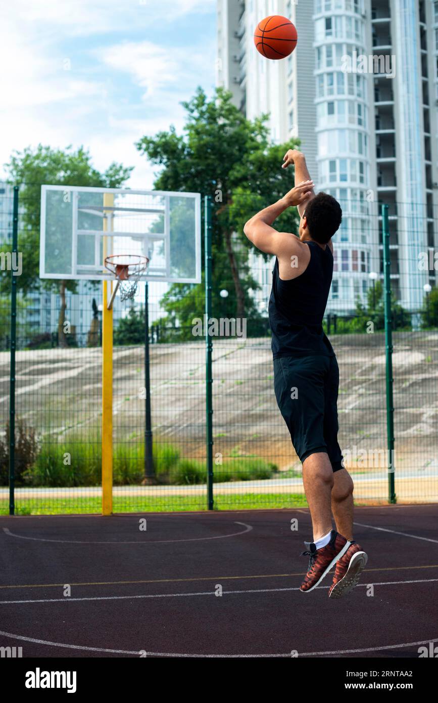 Man throwing ball basketball hoop Stock Photo - Alamy