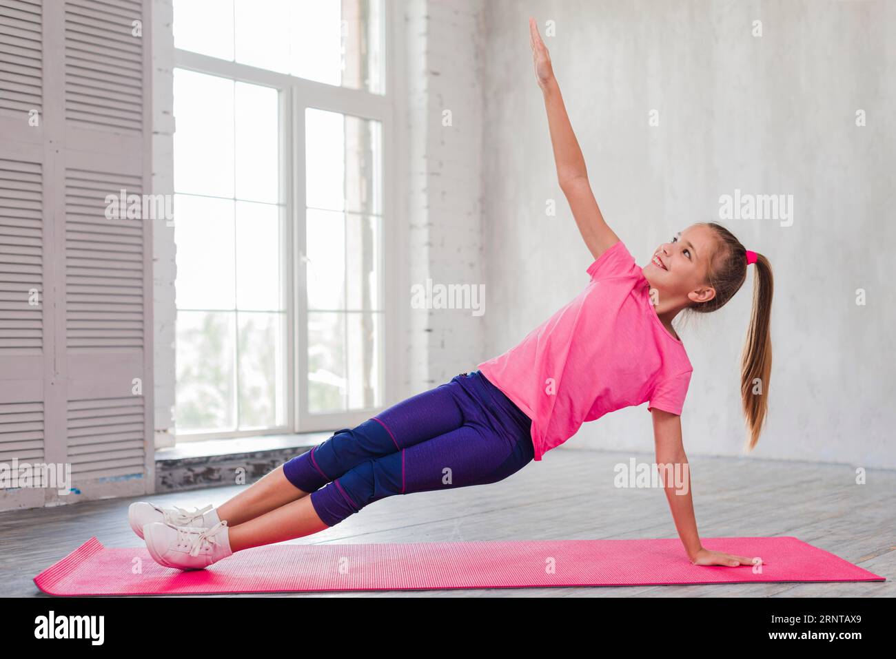 Smiling girl doing stretching exercise gym Stock Photo - Alamy
