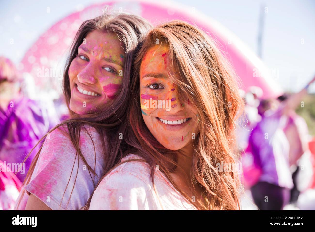 Smiling young women with holi color their face standing back back Stock ...