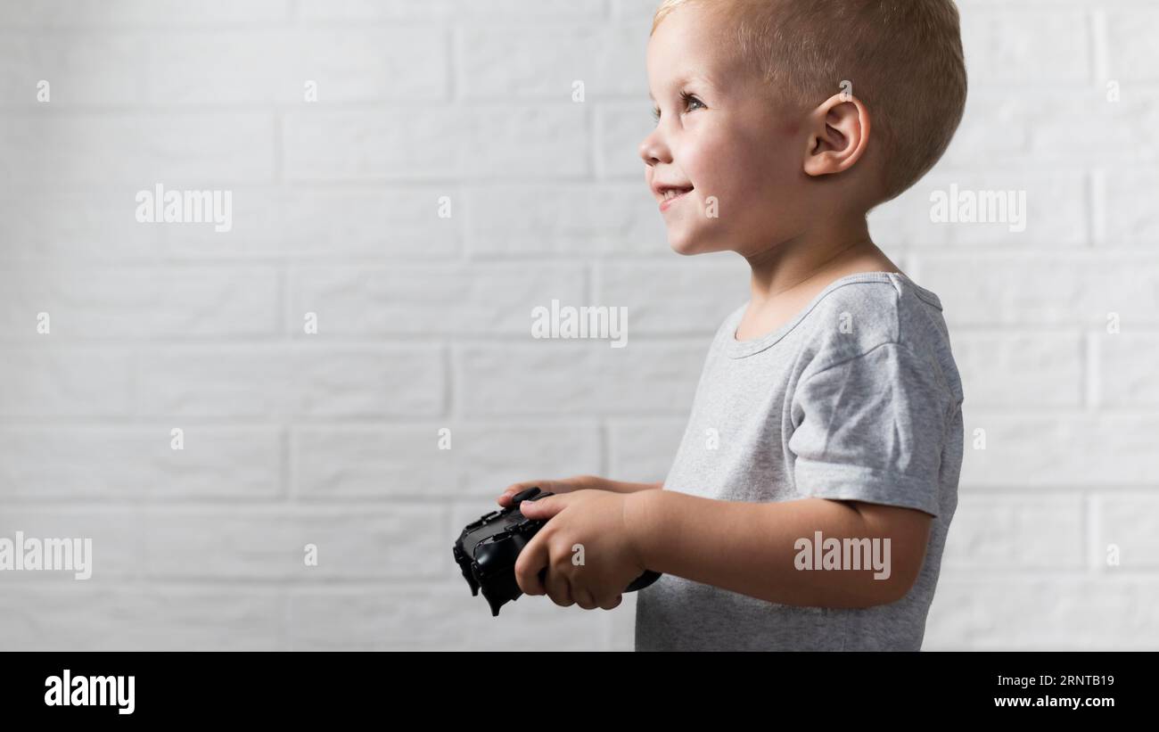 Side view little boy playing with controller Stock Photo - Alamy