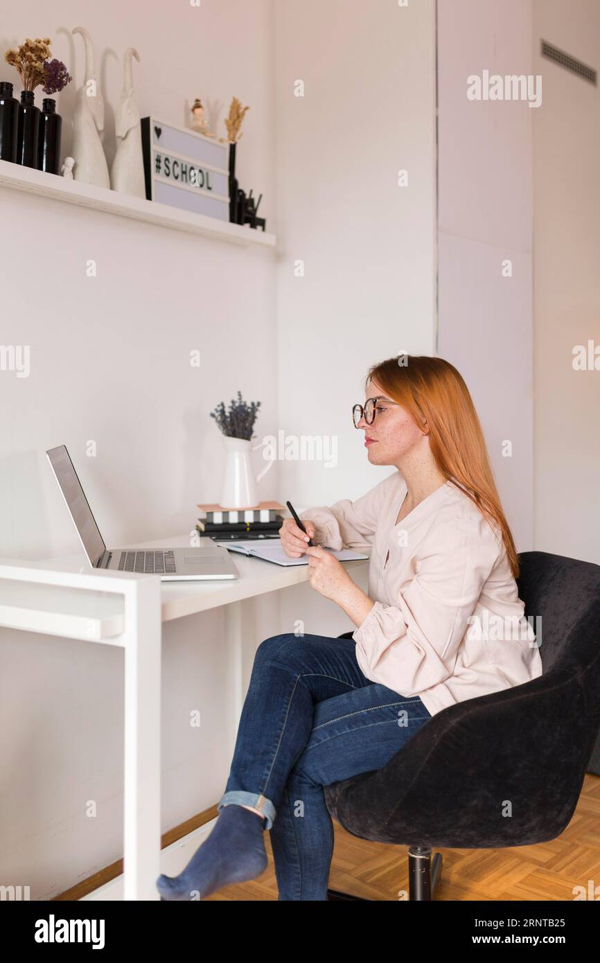 Side view female teacher desk during online class Stock Photo - Alamy