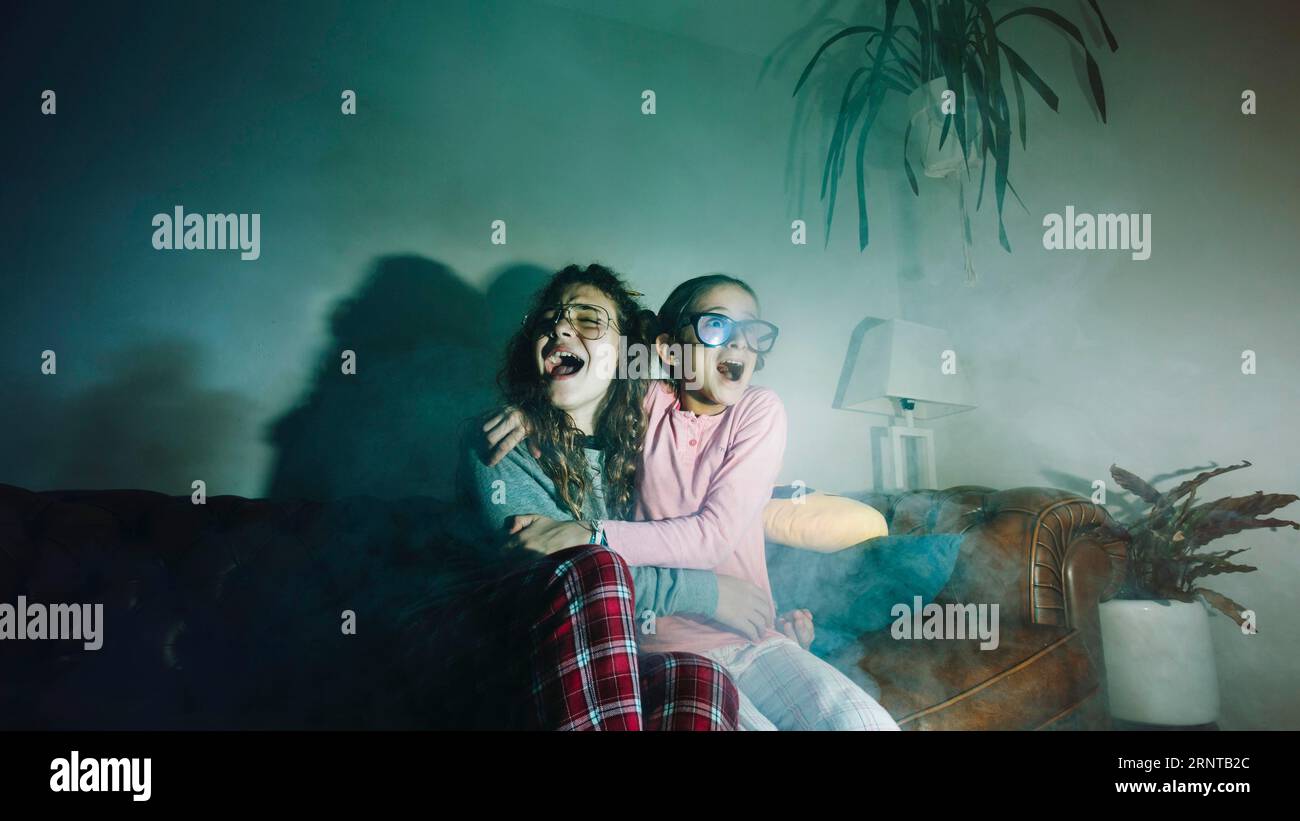 Scared girls watching tv Stock Photo - Alamy