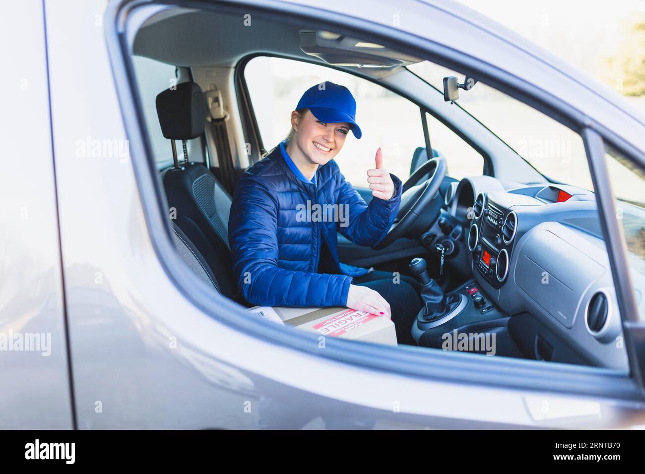 Successful delivery worker showing thumb up Stock Photo - Alamy