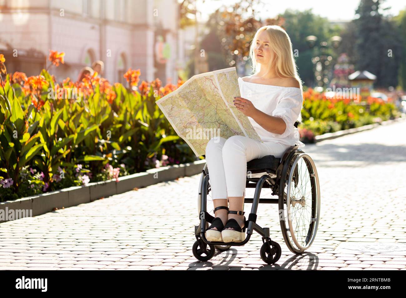 Woman wheelchair looking map outdoors Stock Photo - Alamy