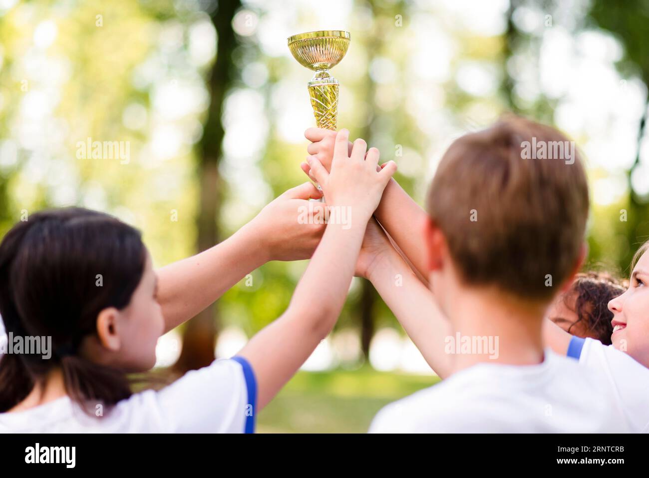 Children holding golden trophy Stock Photo - Alamy