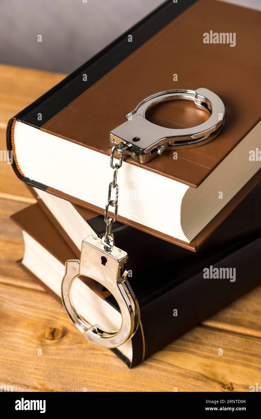 Close up with handcuffs books Stock Photo - Alamy