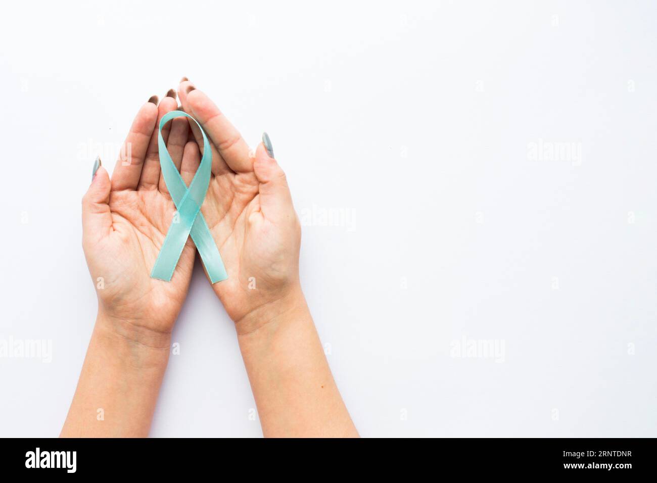 Crop hands with light blue ribbon Stock Photo - Alamy