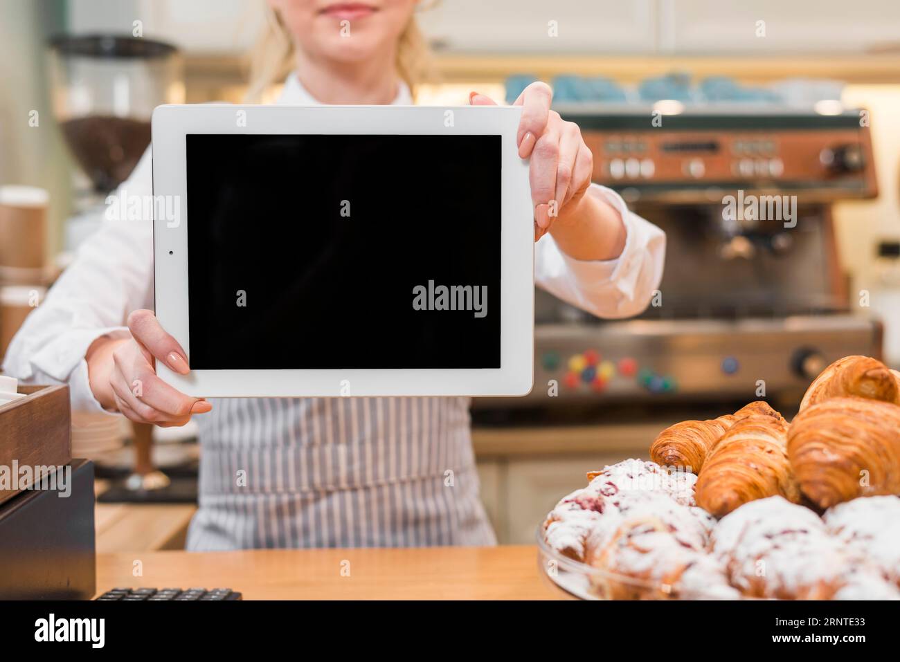 Female baker showing digital tablet front baked croissant counter Stock ...