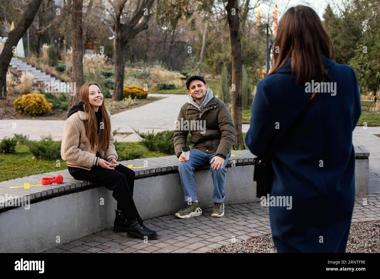 People sitting distance bench Stock Photo - Alamy