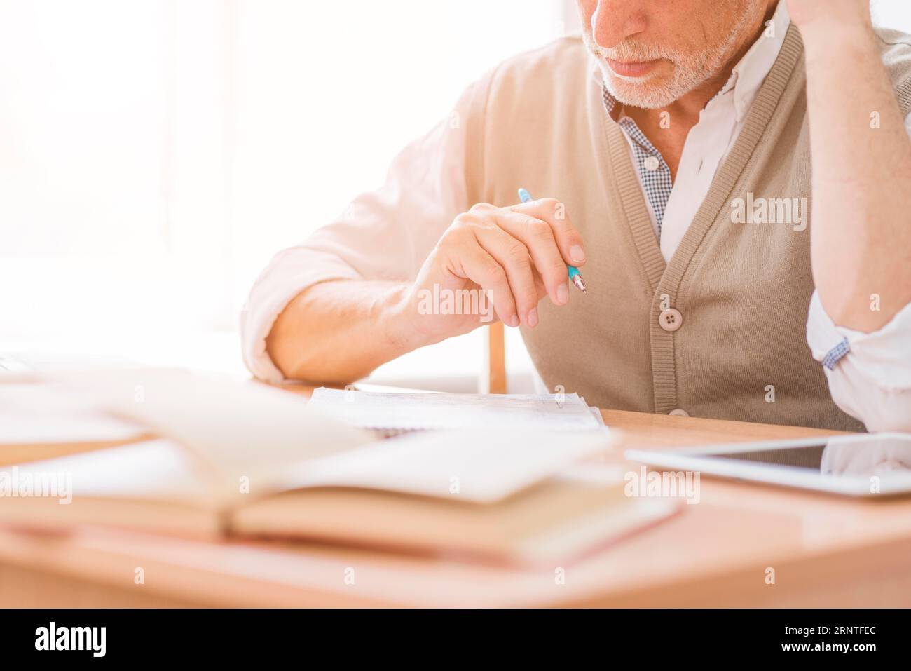 Senior teacher holding pen workplace classroom Stock Photo - Alamy