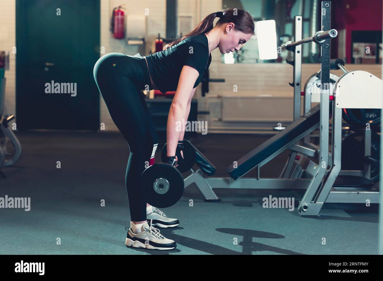 Side view young woman lifting weight fitness center Stock Photo - Alamy
