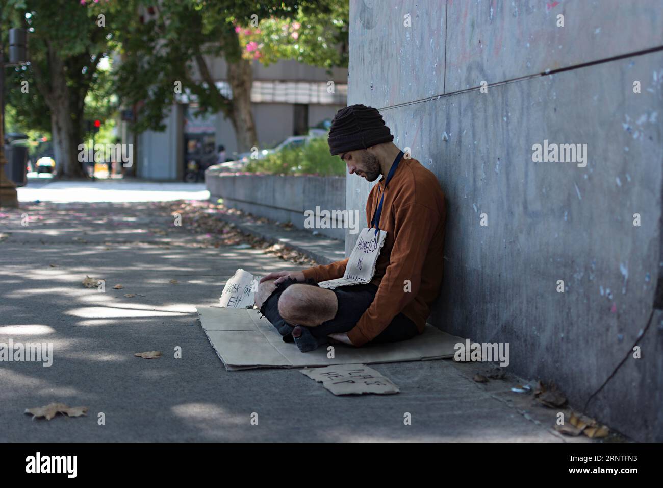 Sideways beggar asking money from strangers Stock Photo - Alamy