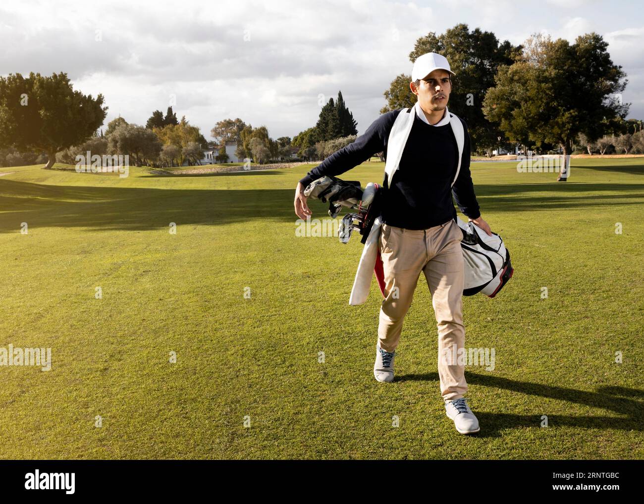 Front view man with golf clubs field Stock Photo - Alamy