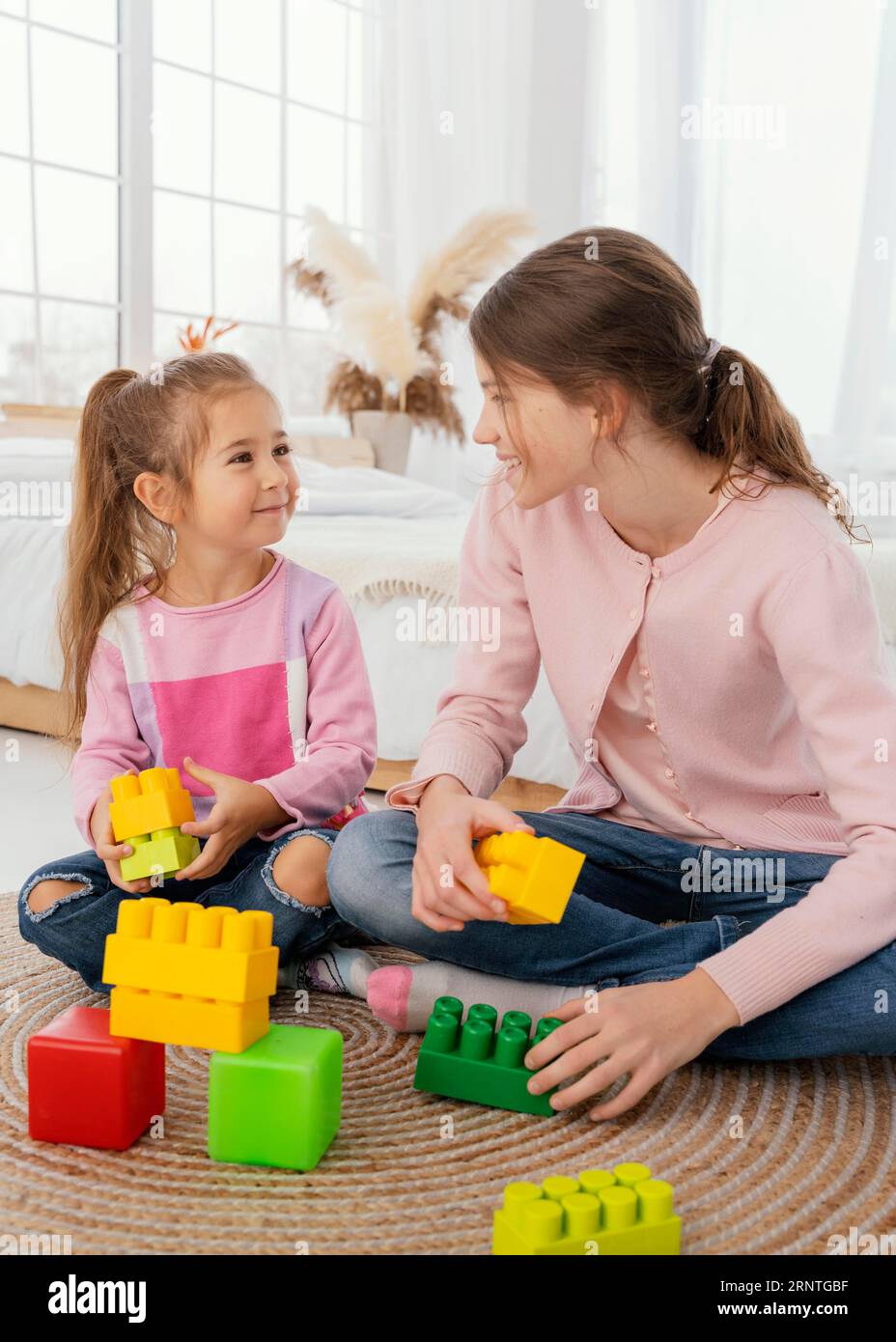 Front view two sisters playing with toys Stock Photo - Alamy