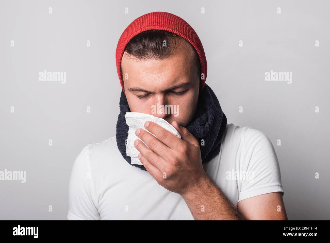 Young man suffering from cold flu against gray background Stock Photo ...