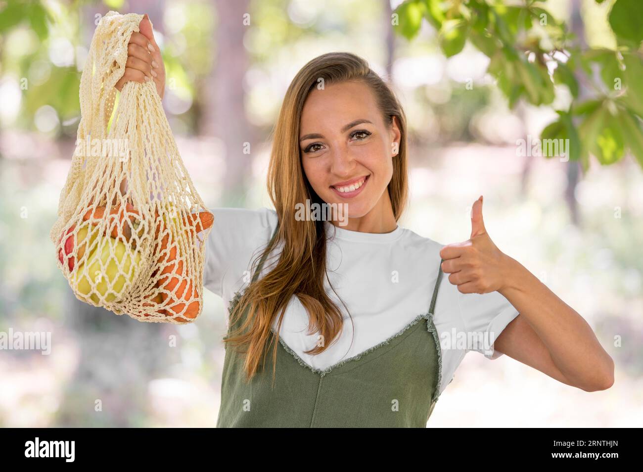 Woman doing thumbs up sign biodegradable bag with goodies Stock Photo ...