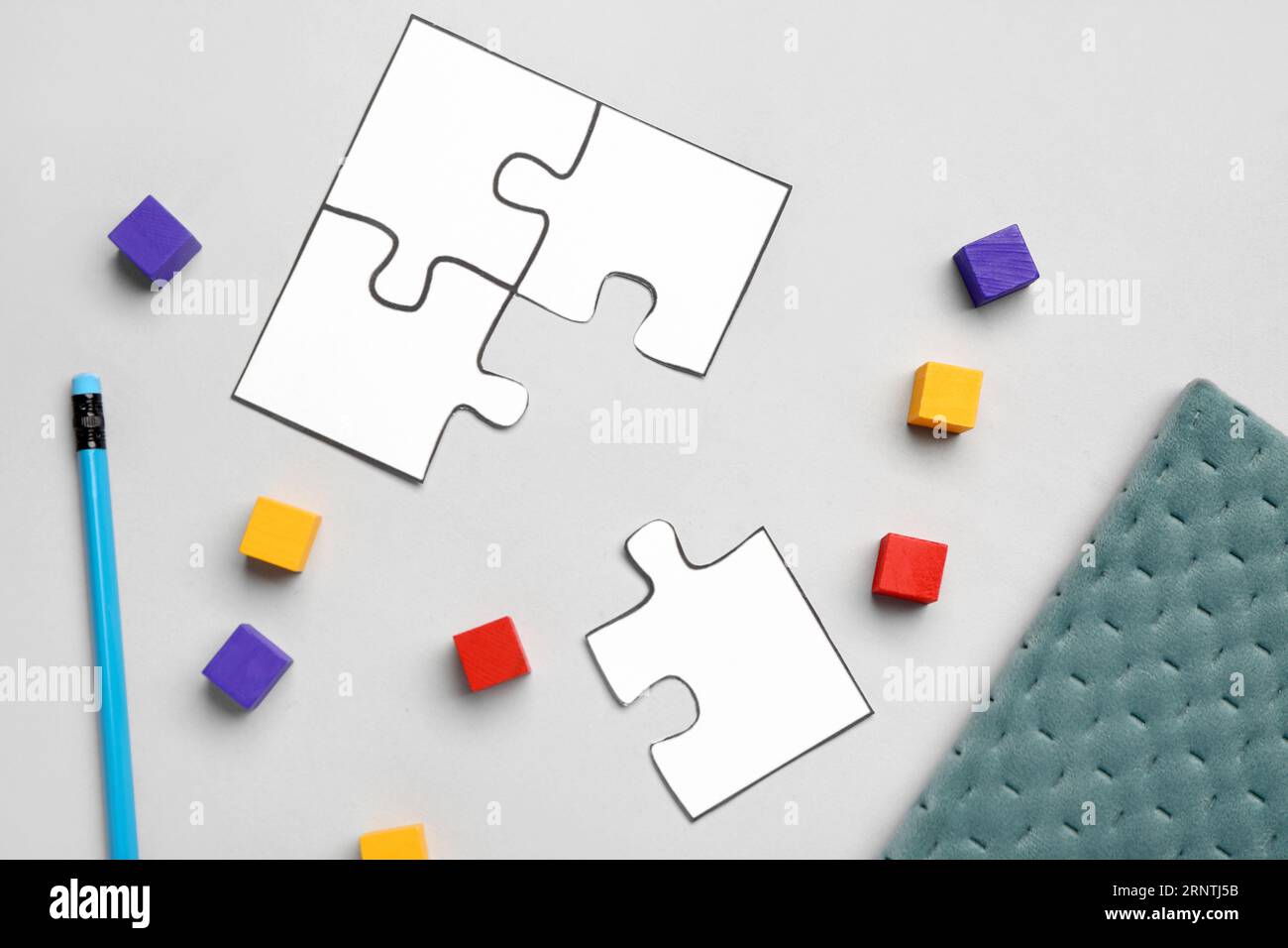 Paper puzzle pieces with cubes and notebook on light background. Logic ...