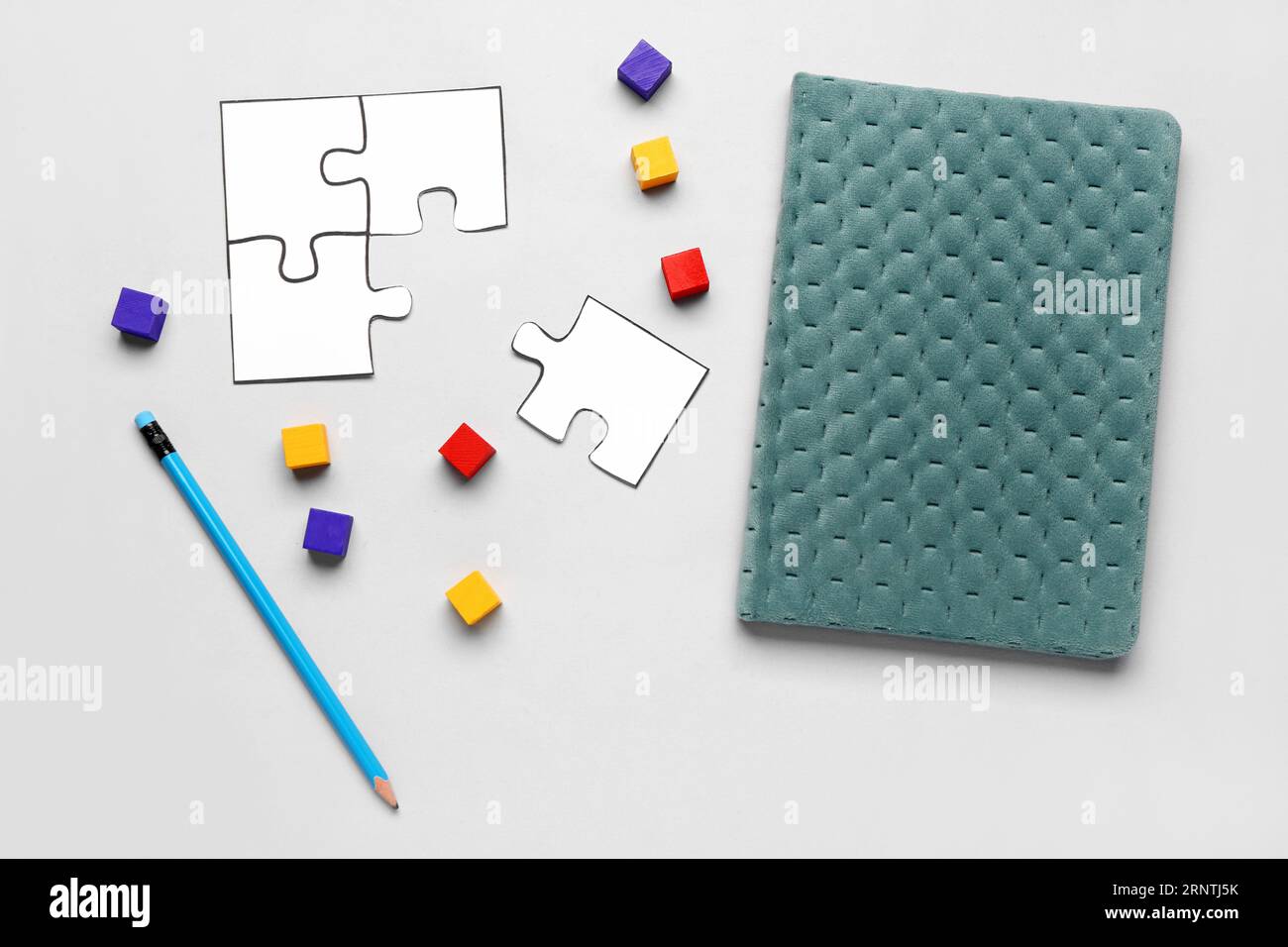 Paper puzzle pieces with cubes and notebook on light background. Logic ...
