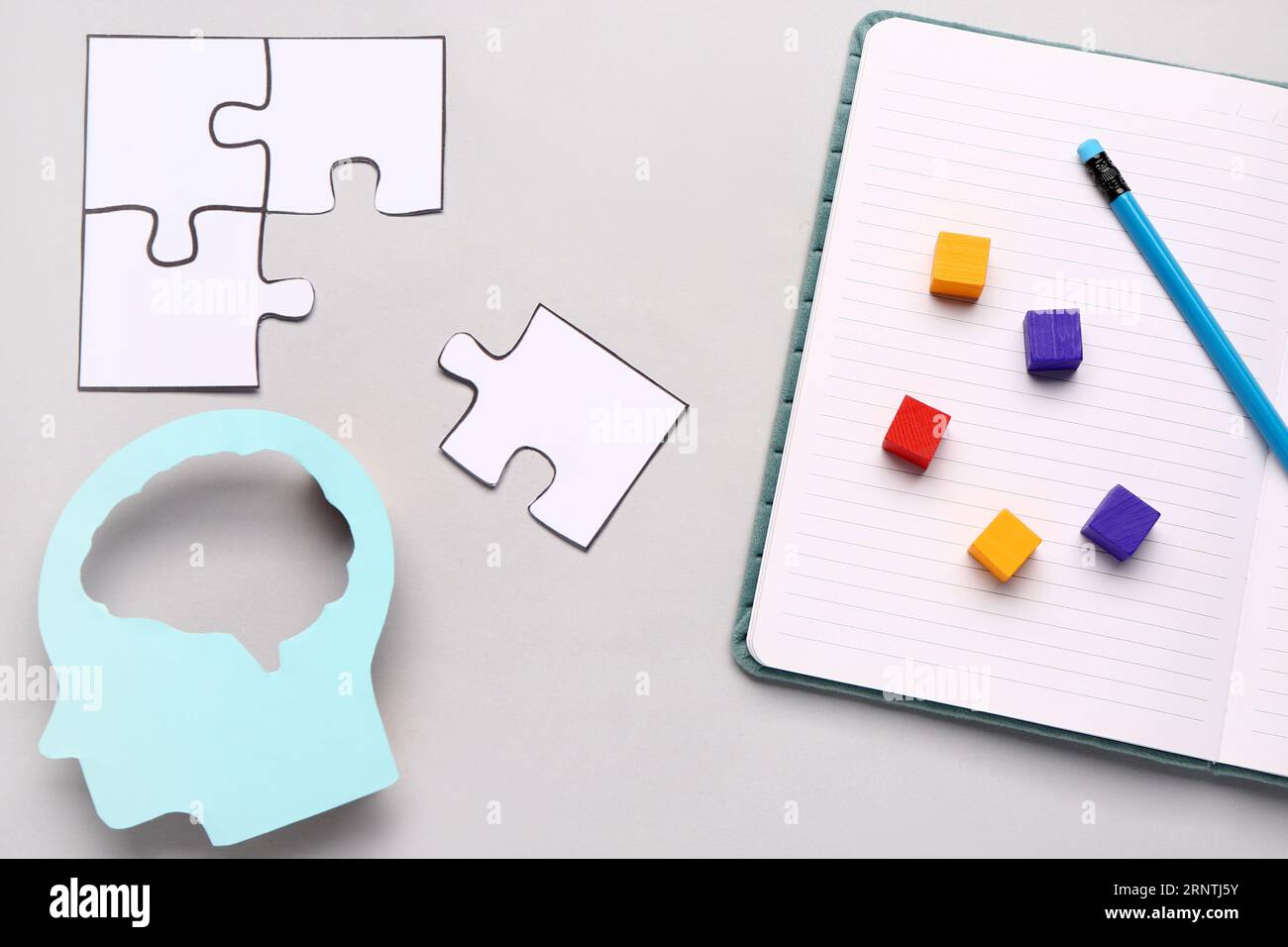 Notebook with cubes, paper human head and puzzle pieces on light ...