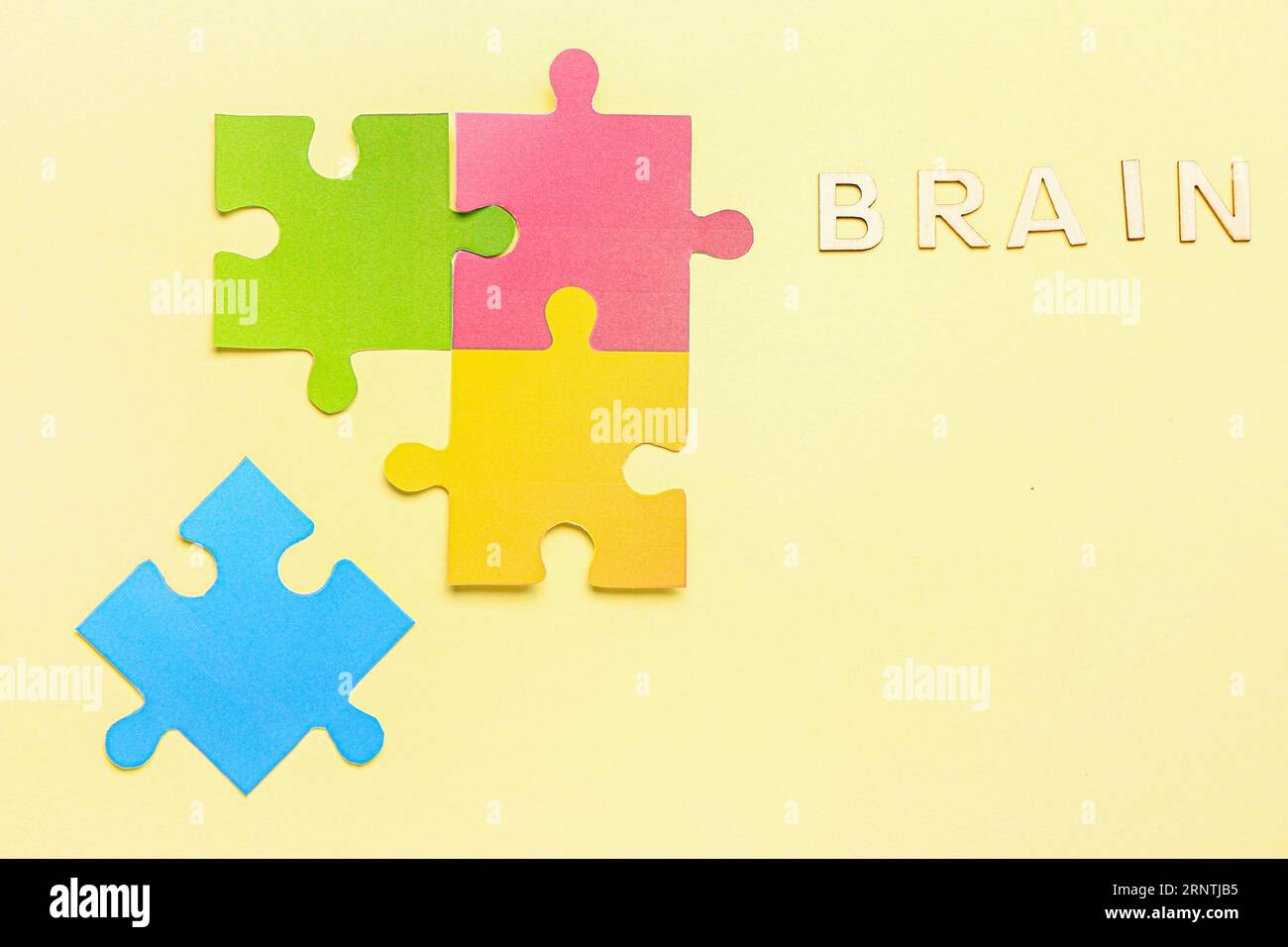 Word BRAIN with paper puzzle pieces on yellow background. Logic concept ...