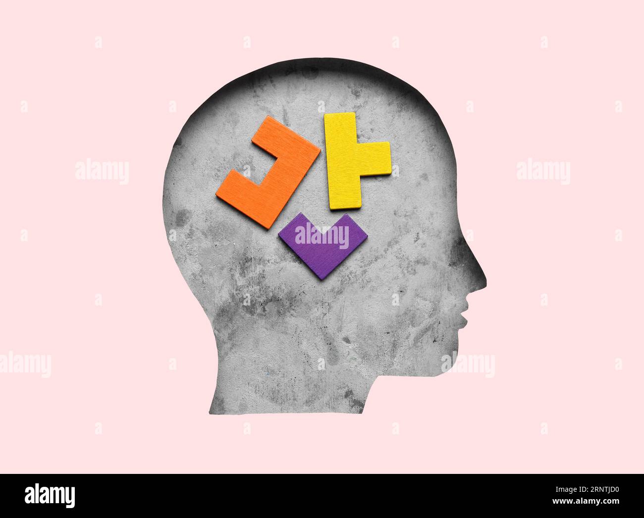 Blocks visible through cut pink paper in shape of human head on grunge ...