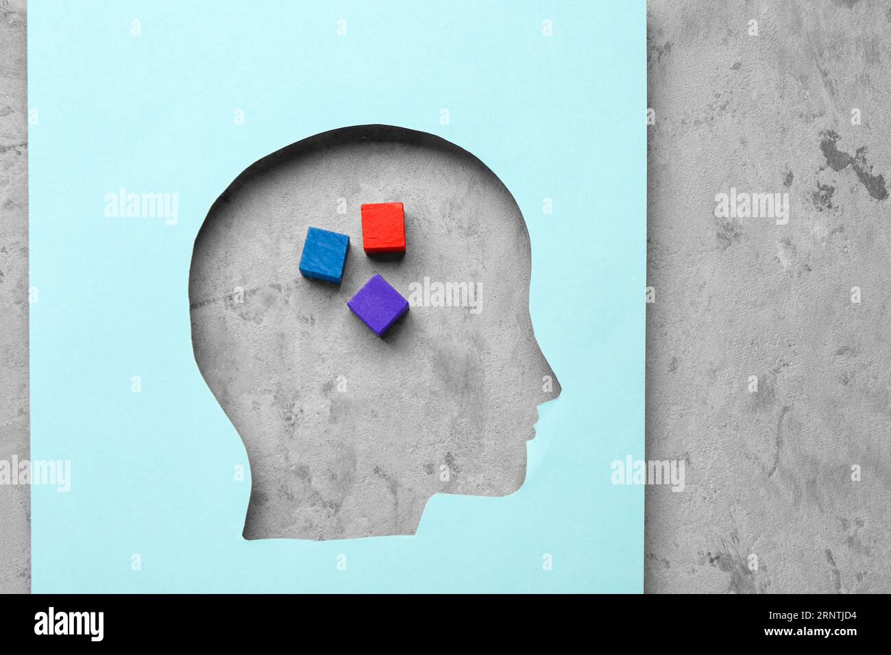 Cubes visible through cut blue paper in shape of human head on grunge ...