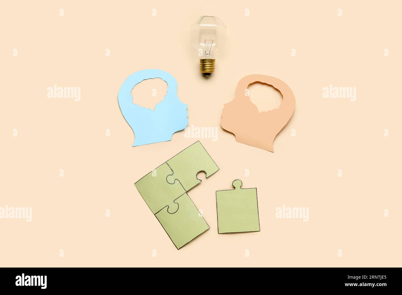 Paper human heads with puzzle pieces and light bulb on beige background ...