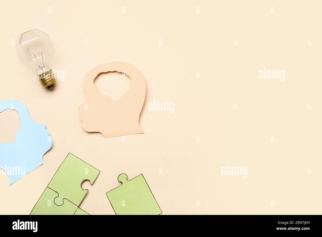 Paper human heads with puzzle pieces and light bulb on beige background ...