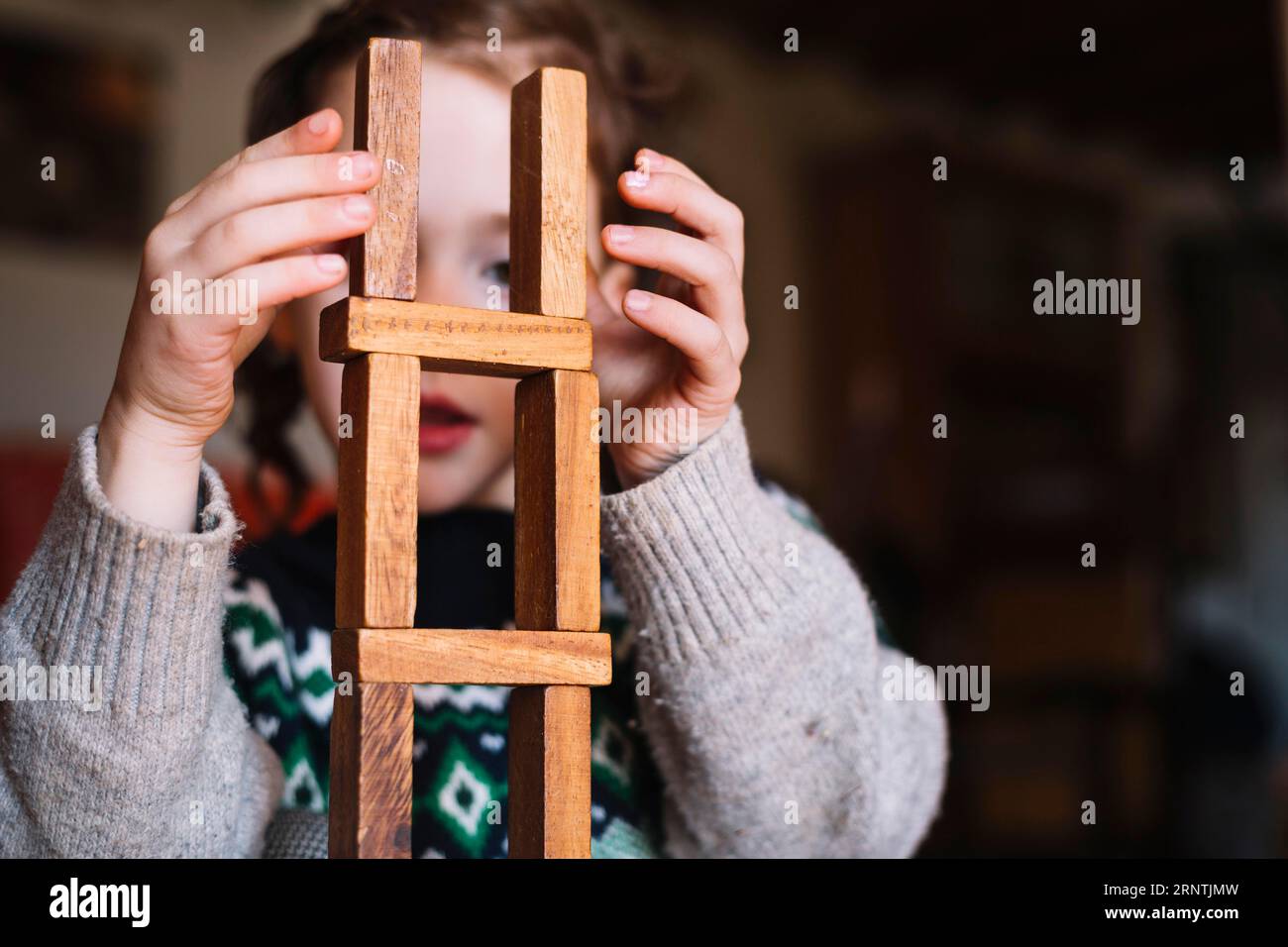 Close up girl balancing stacked wooden blocks Stock Photo - Alamy
