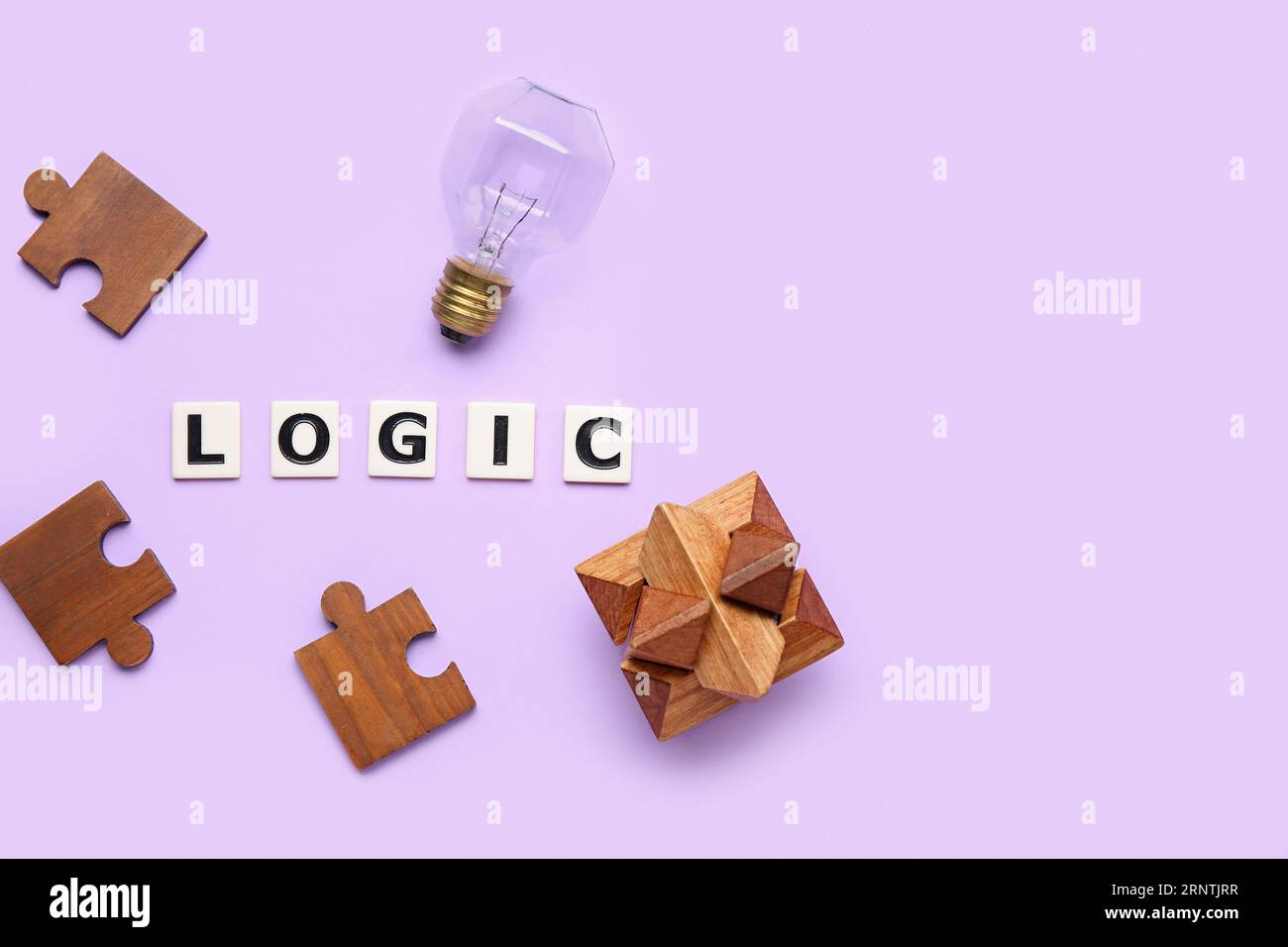 Word LOGIC with light bulb, wooden toy and puzzle pieces on lilac ...