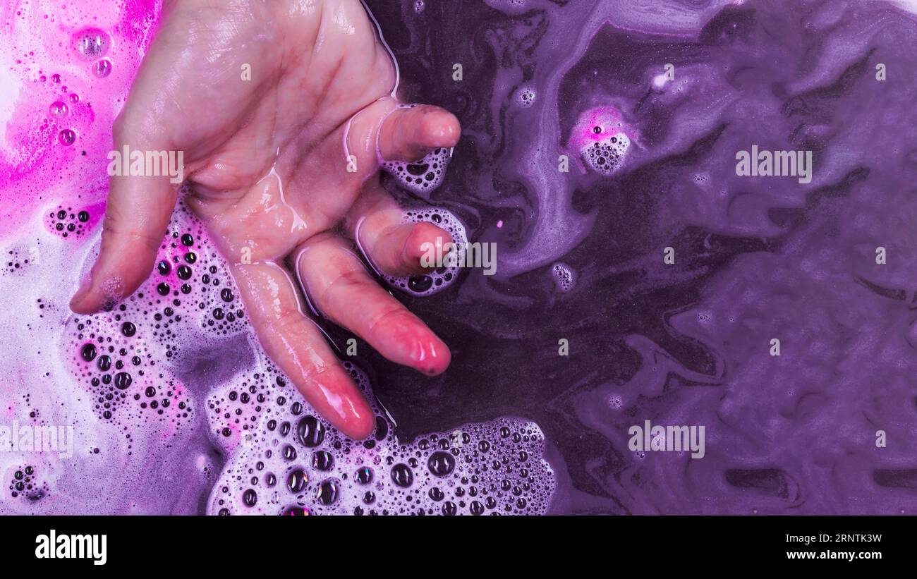 Hand violet liquid with pink foam blobs Stock Photo - Alamy