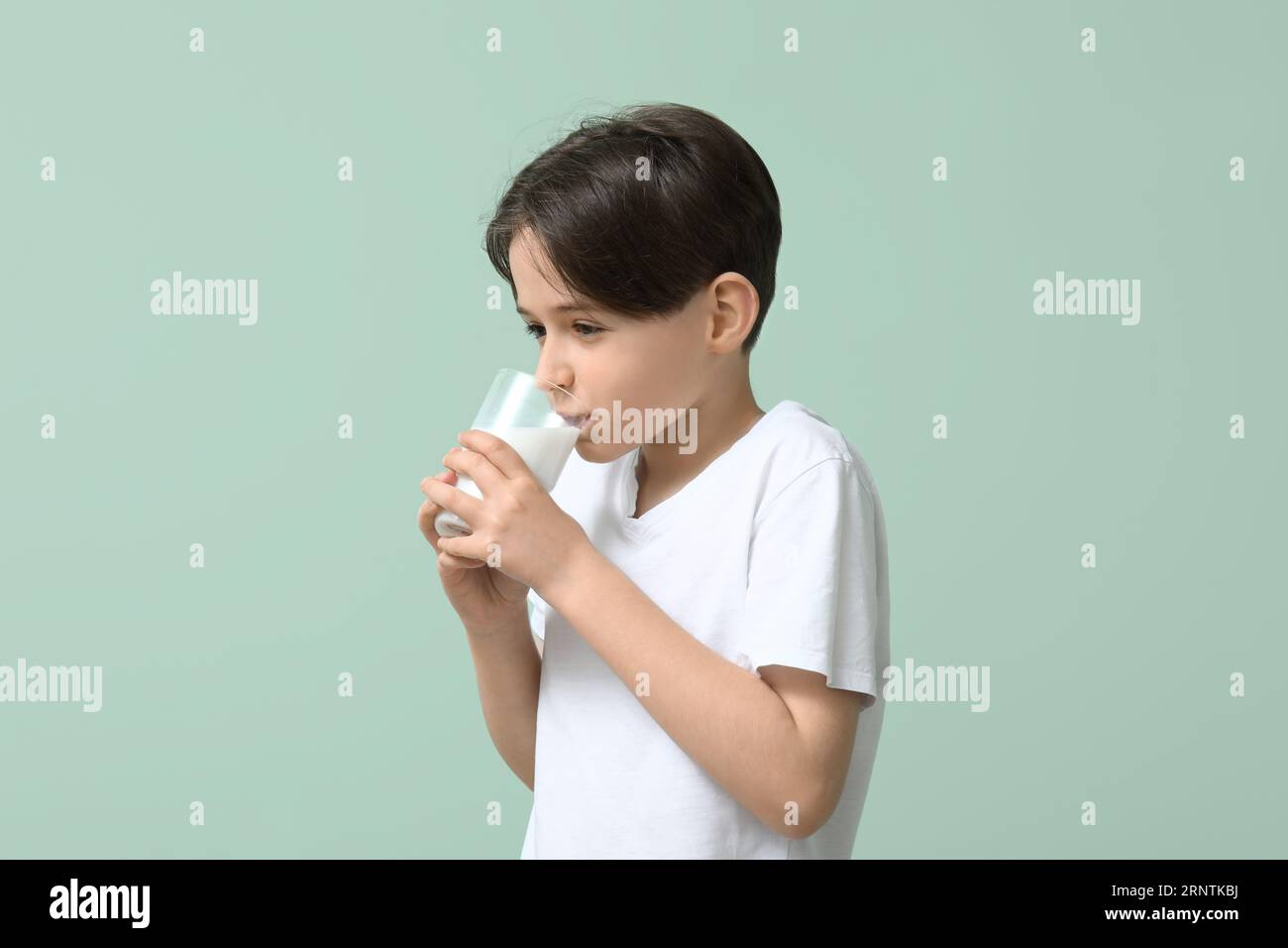 Little boy drinking fresh milk on turquoise background Stock Photo - Alamy