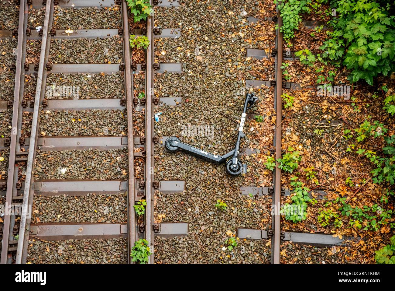 An electric scooter lies overturned between two railway tracks in ...