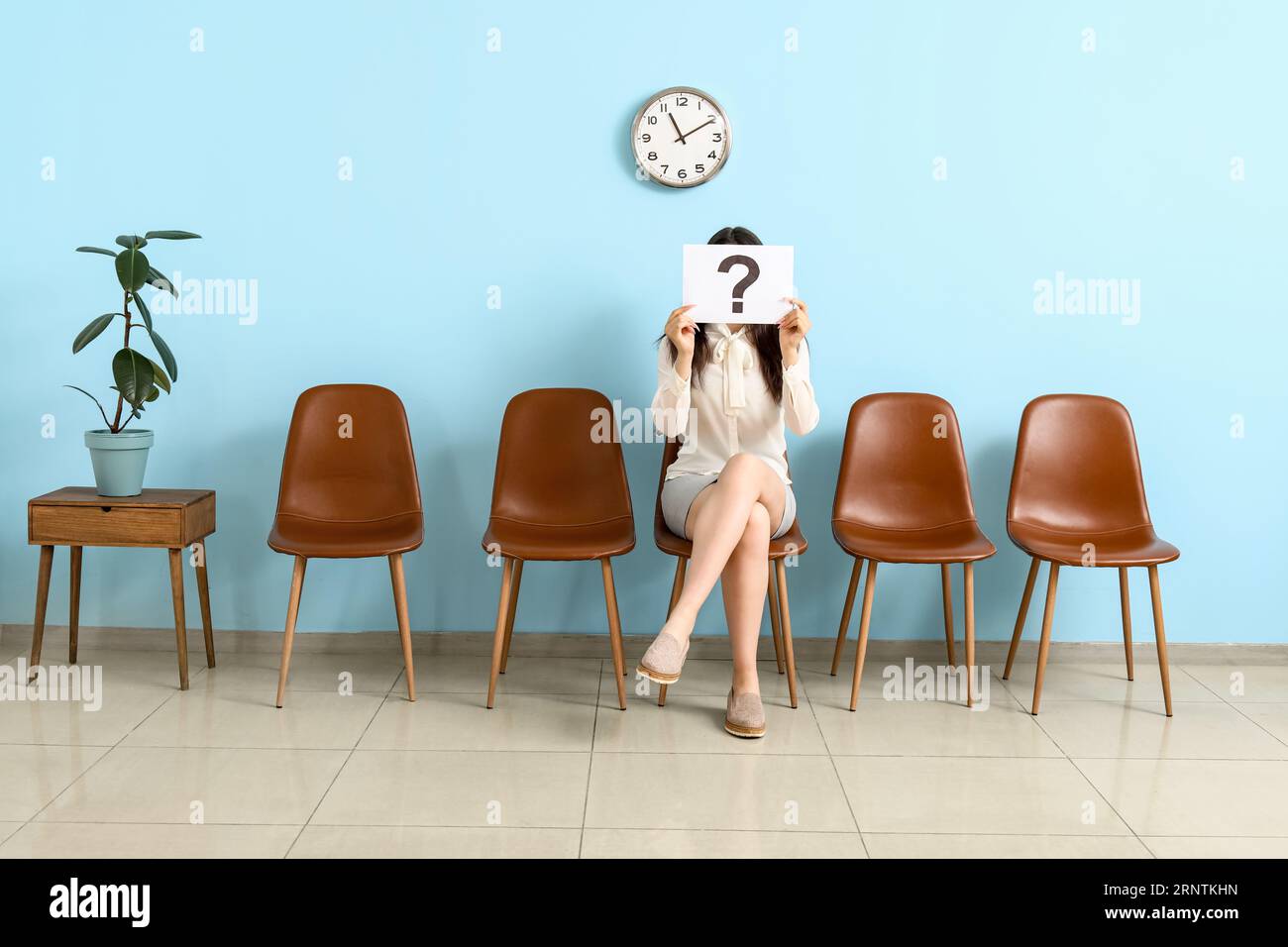 Female applicant holding paper with question mark in room Stock Photo ...