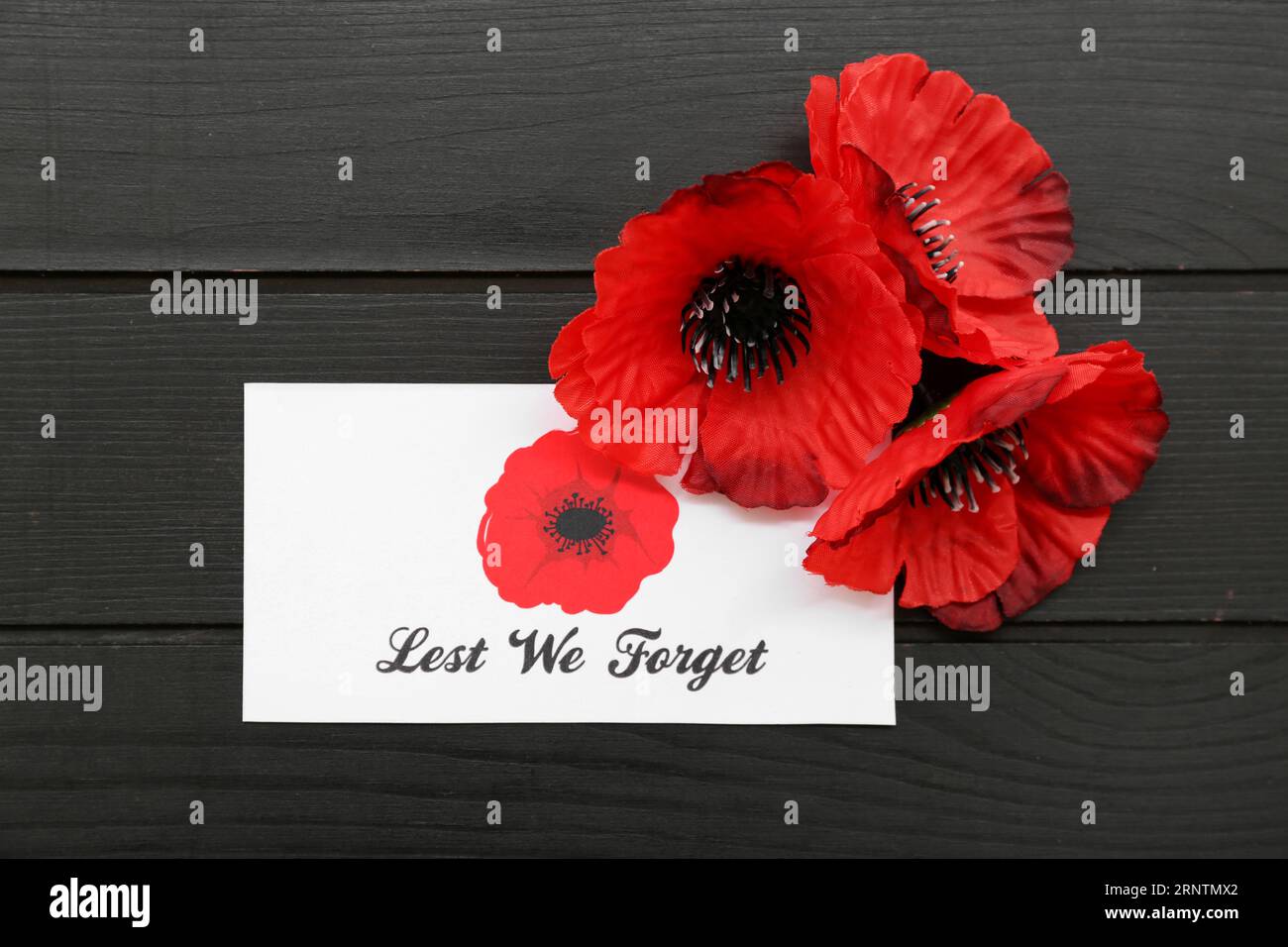 Red poppy flowers with card on black wooden background. Remembrance Day ...