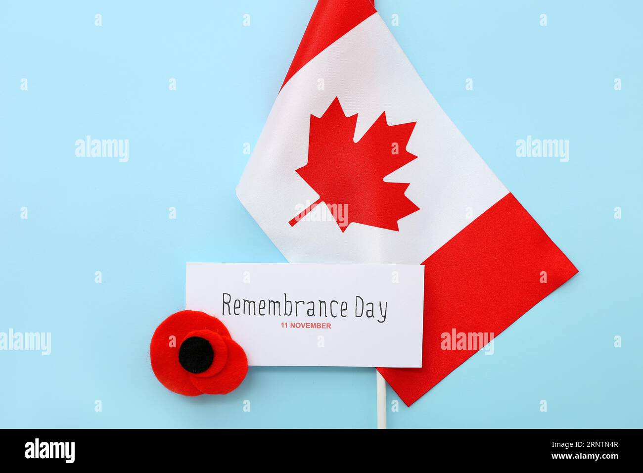 Poppy flower, flag of Canada and card on blue background. Remembrance ...