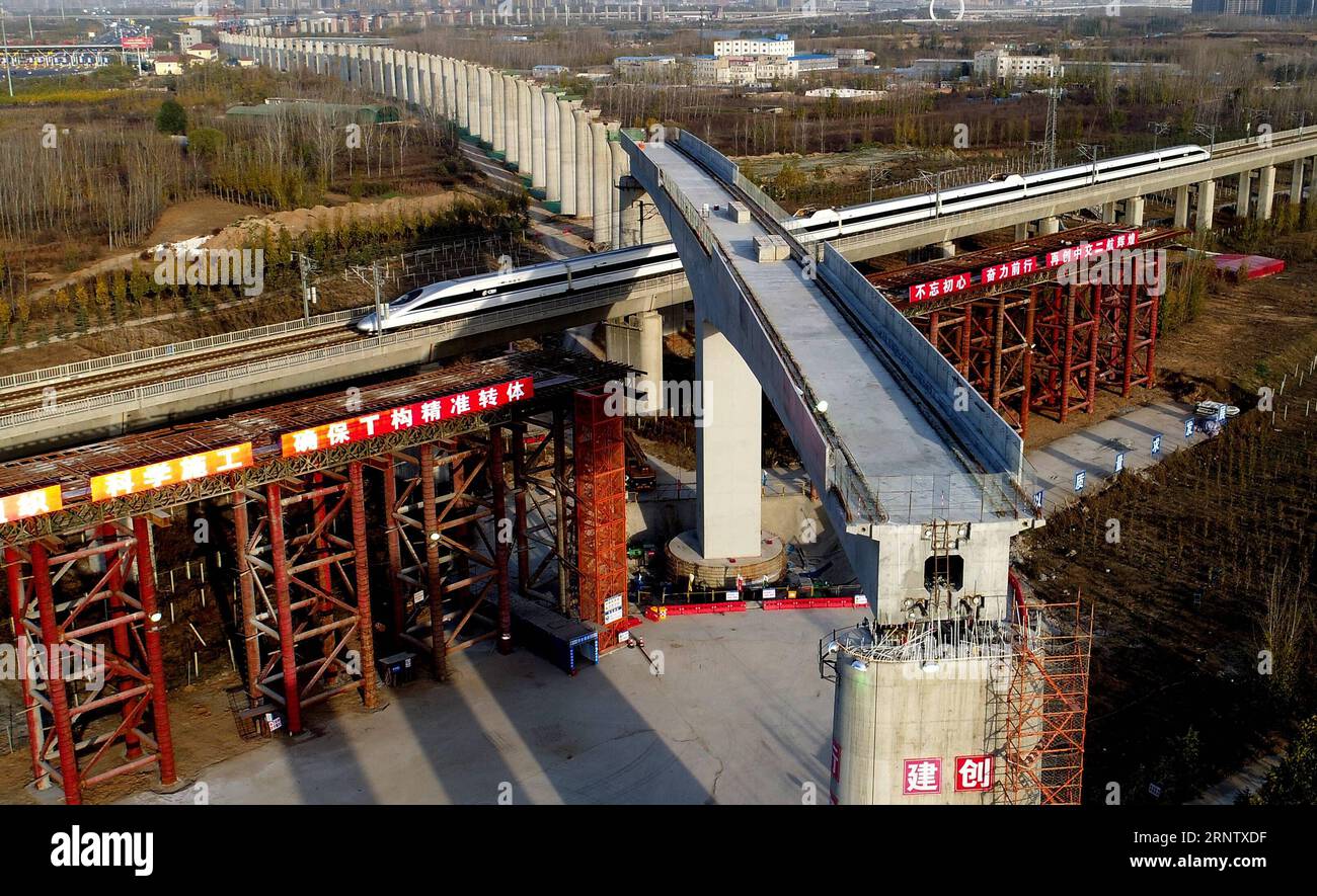 (171122) -- ZHENGZHOU, Nov. 22, 2017 -- A train runs across under a T ...