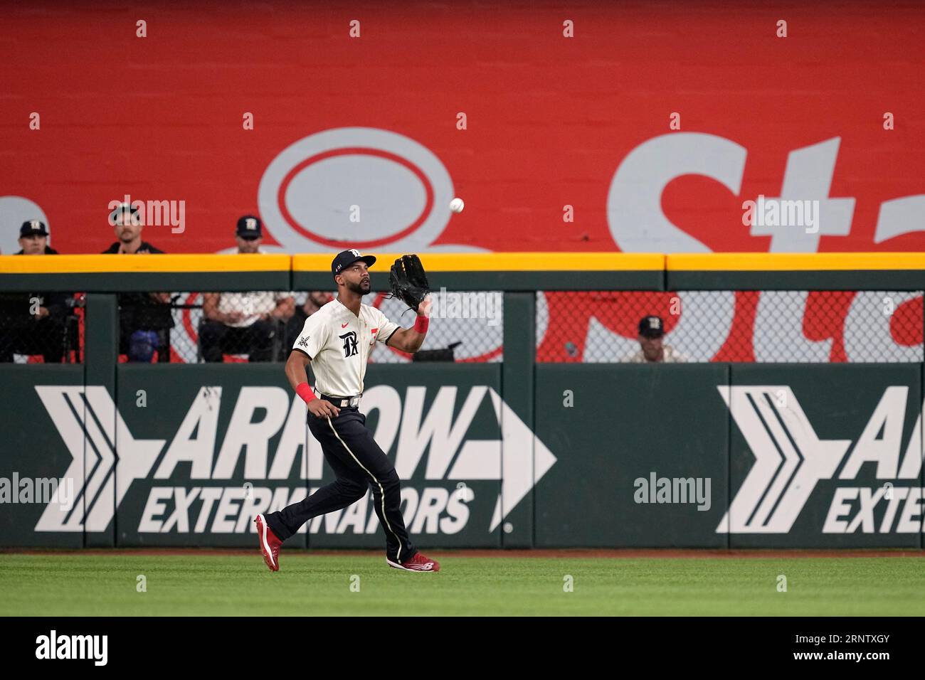 Texas Rangers center fielder Leody Taveras reaches up to catch a fly ...