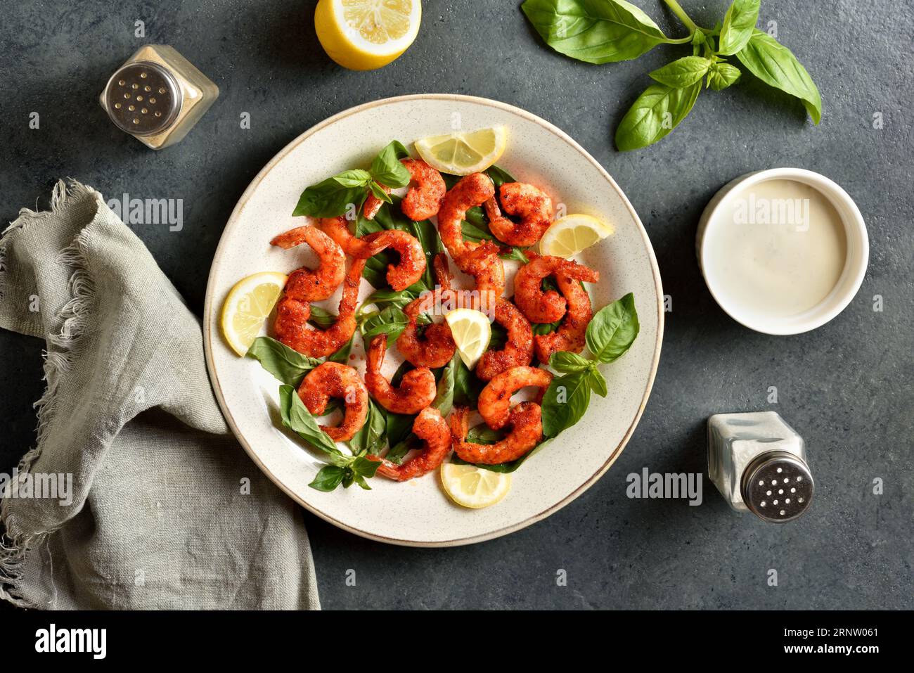 Spicy thai basil shrimp on plate over dark stone background. Top view ...