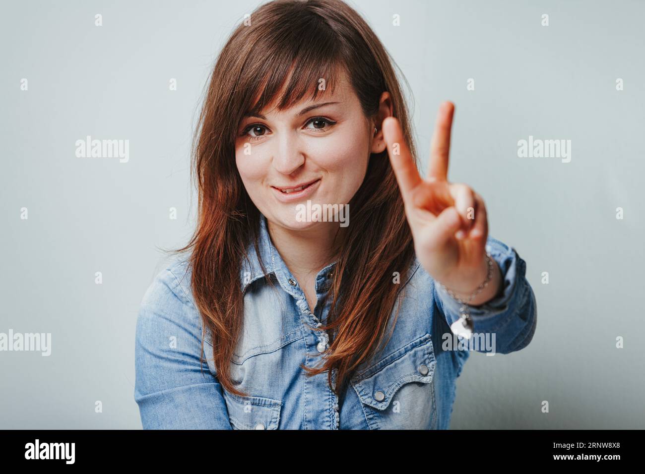 Gleaming with triumph, a denim-clad brunette displays victory. The ...